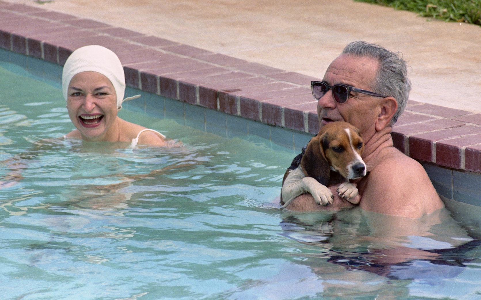 Photo - LBJ, holding beagle, and Lady Bird swim at the LBJ ranch, June ...